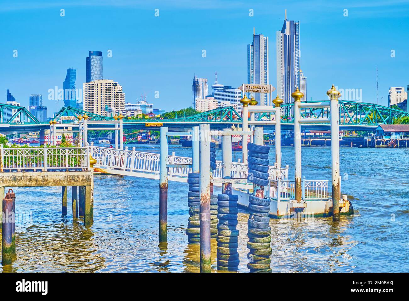 The passenger Yodpiman pier on Chao Phraya river and modern city on ...