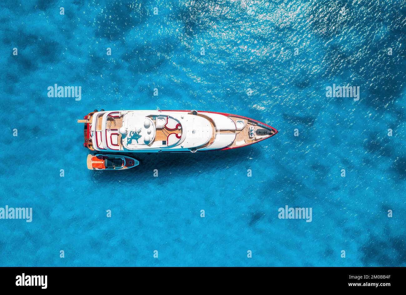 Aerial view of speed boat in crystal clear turquoise water at sunset ...