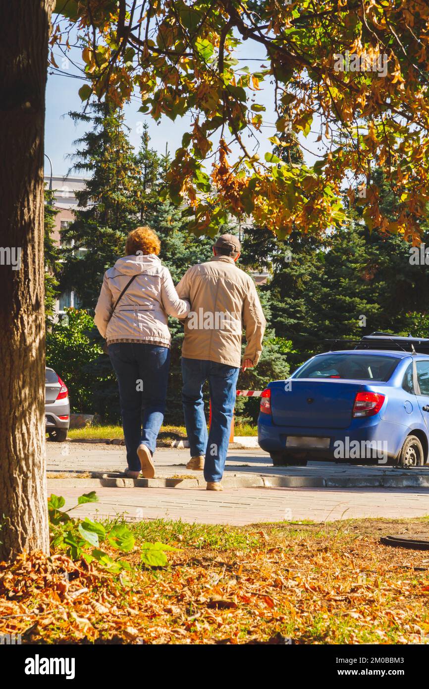 Couple walking through park holding hi-res stock photography and images ...