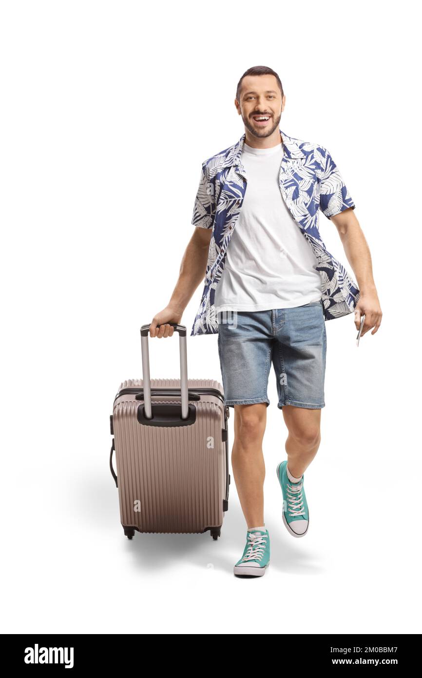 Full length portrait of a smiling man walking and pulling a suitcase ...