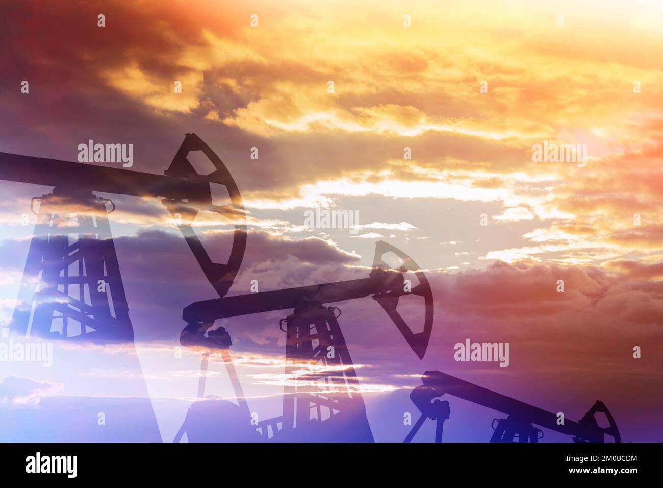 Oil production against backdrop of sunset. Rigs. Oilfield Stock Photo ...