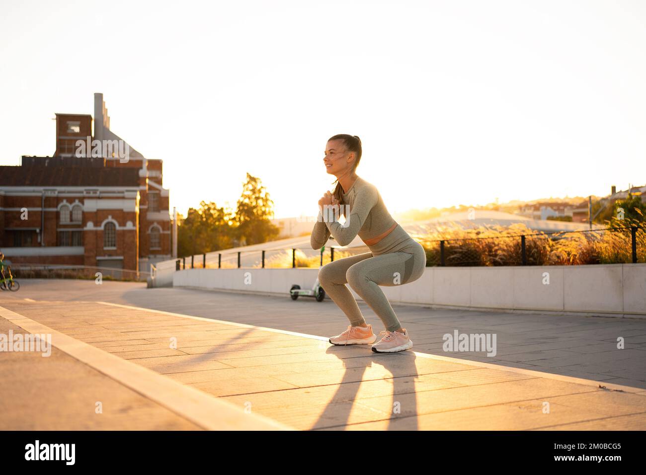 Sporty woman doing jumping squats exercises on stairs in park ...