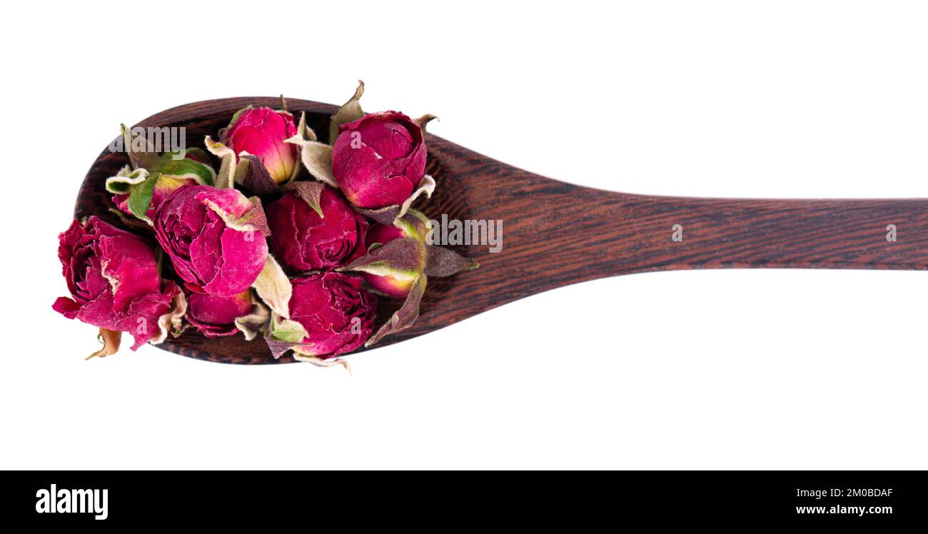 Heap of dry tea roses buds in wooden spoon, isolated on white ...