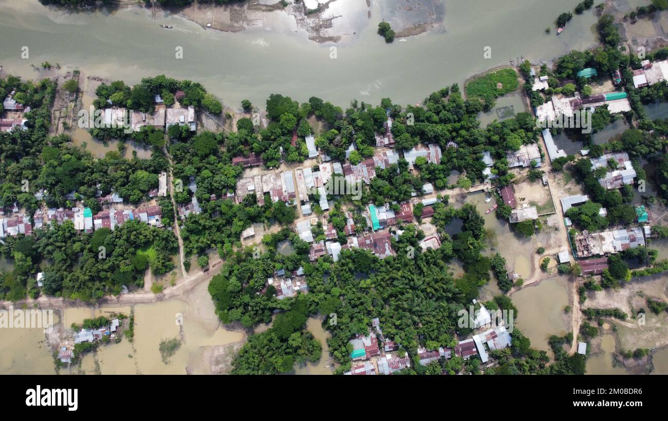 A top view of shore buildings surrounded by lush trees and mud flats at ...