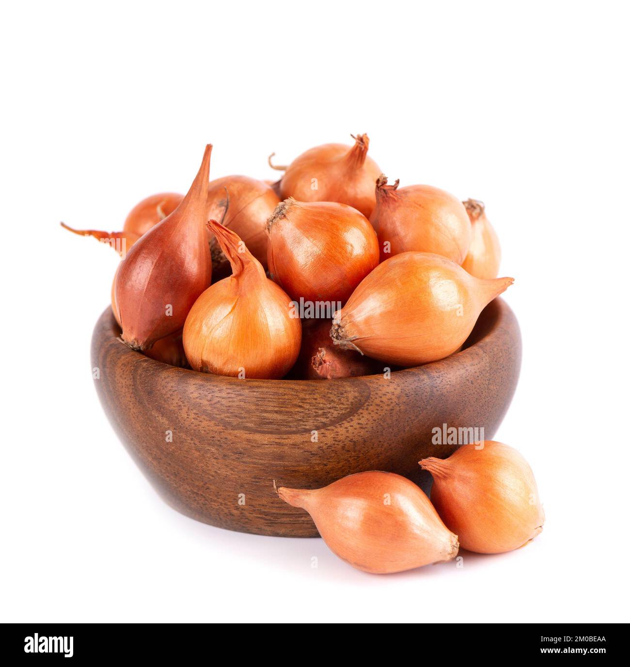 Brown mini onions in wooden bowl, isolated on a white background. Raw ...