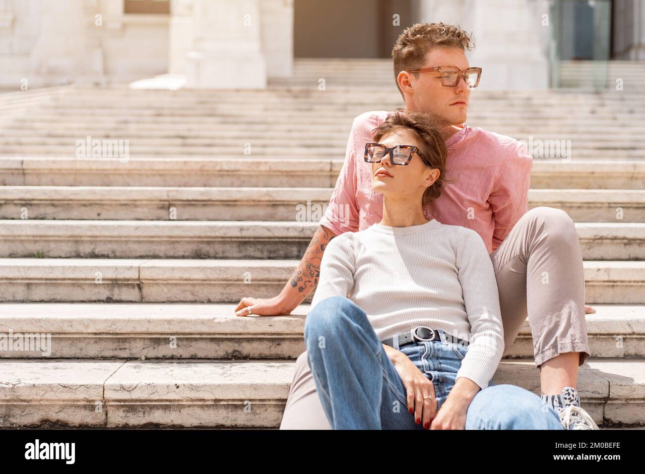 Young beautiful hipster couple in love sitting stairs on old city ...