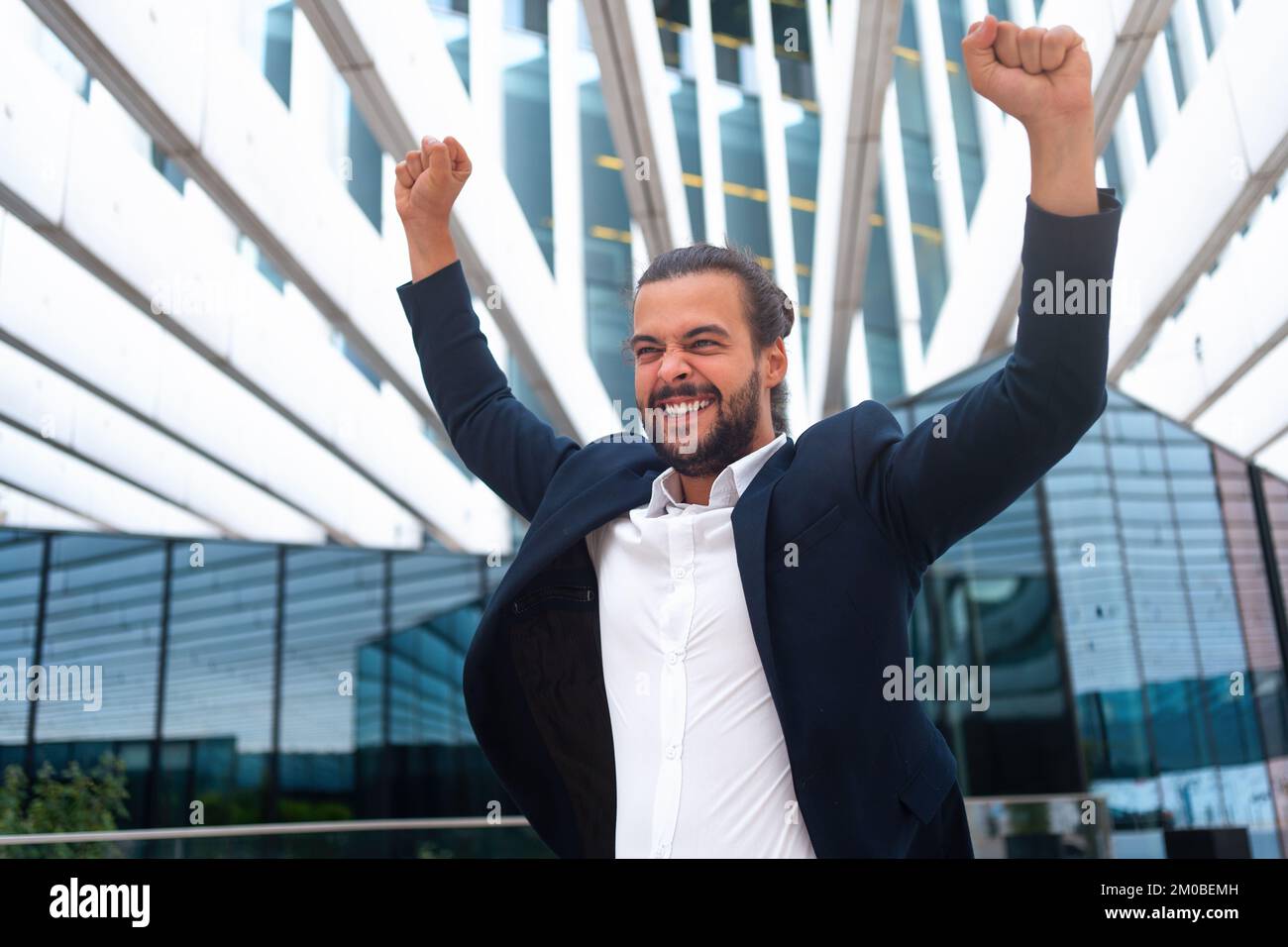 Excited businessman in suit celebrating victory arms raised up ...