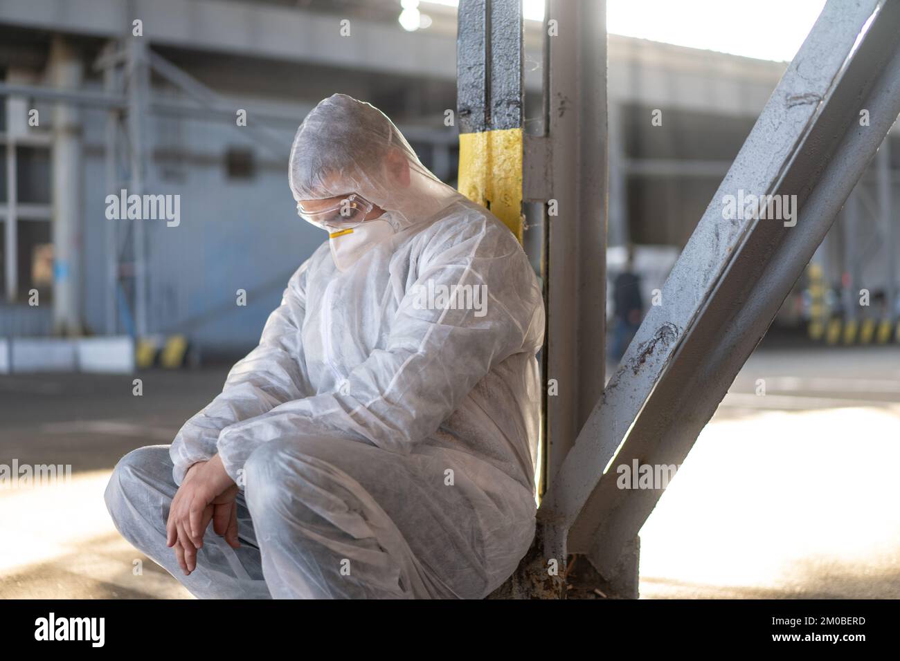 Despair healthcare worker in white covid protective overalls.Tired Male ...