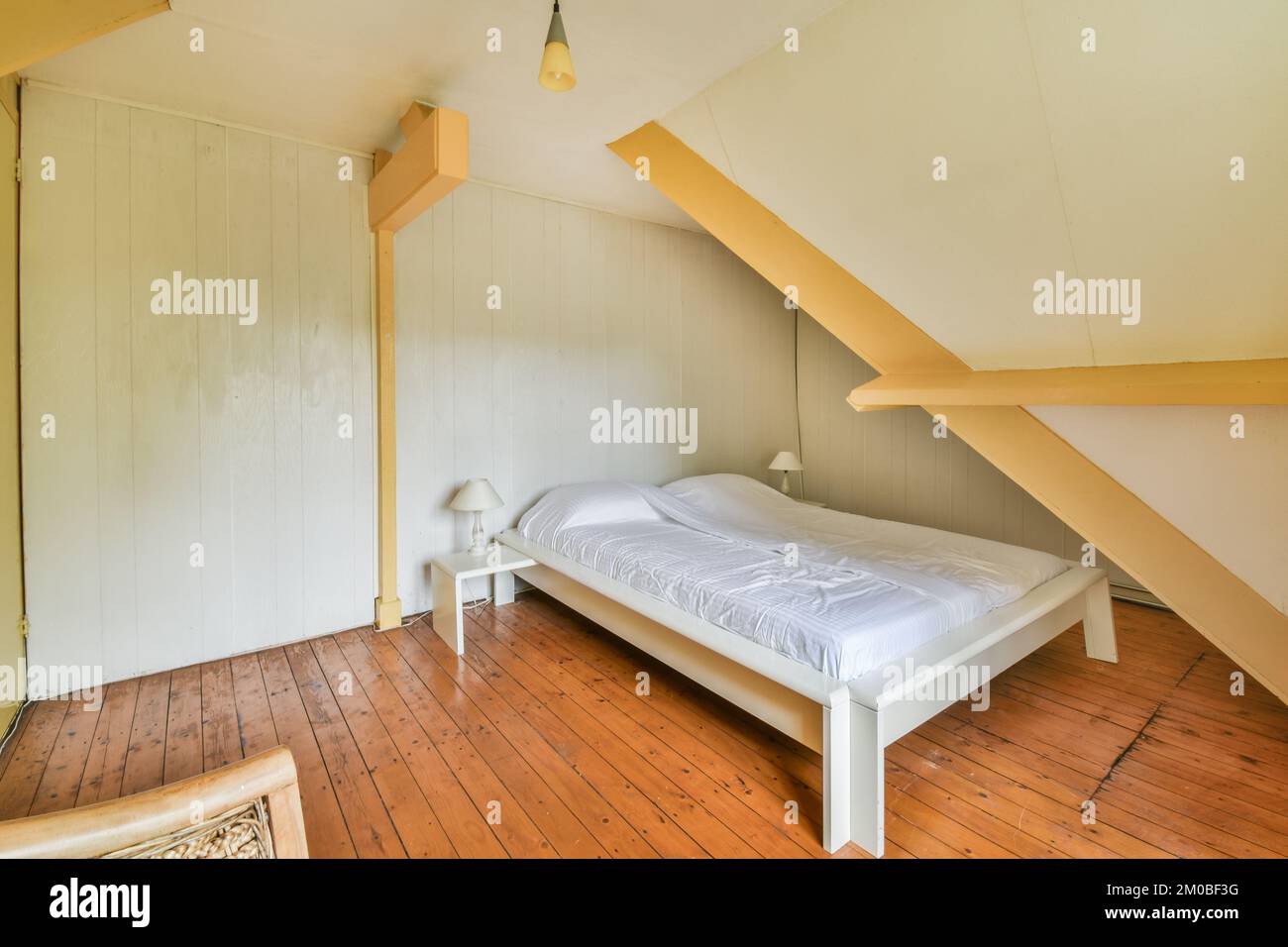 Comfortable bed with white bedclothes and bedside table with lamp ...