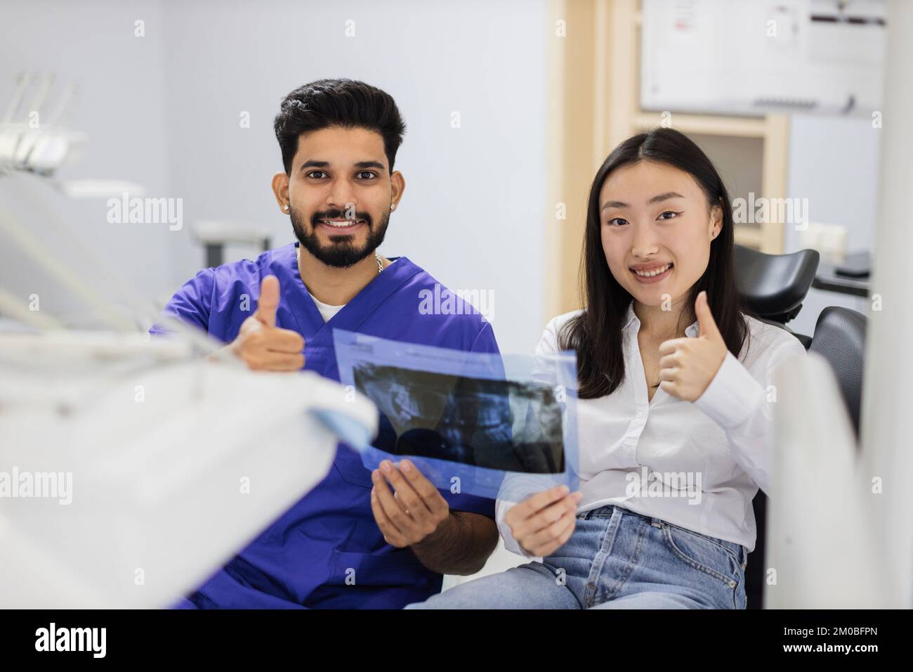 Smiling happy asian woman visiting dentist, sitting in dental chair at ...