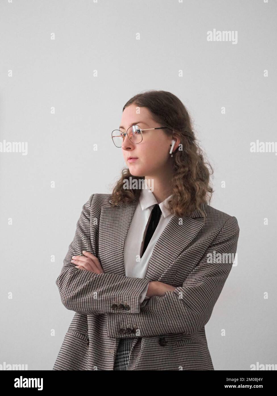 A vertical shot of a young woman dressed in classic style and wearing ...