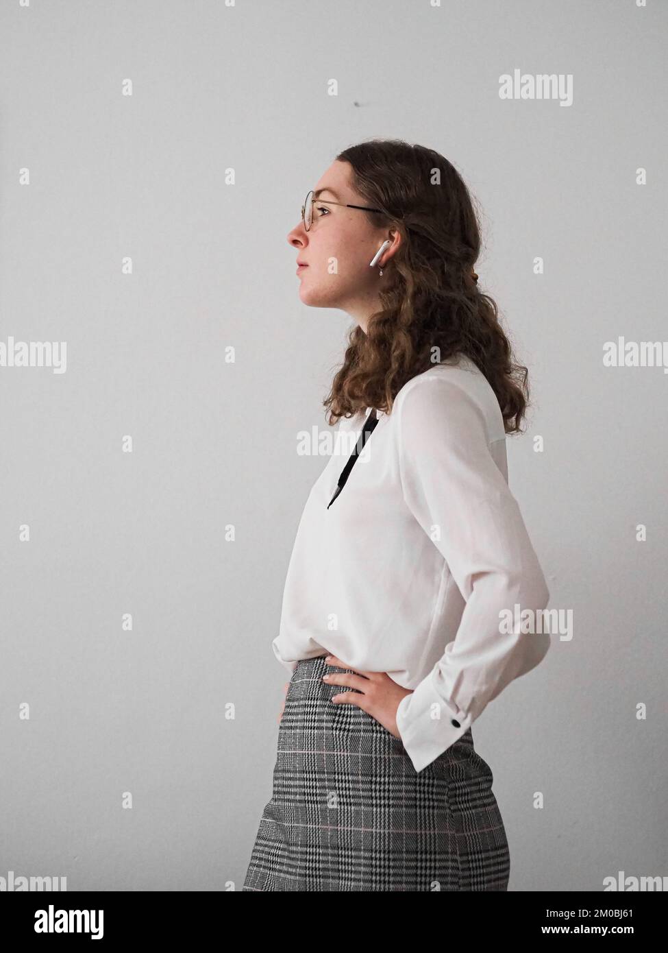 A vertical shot of a young woman dressed in classic style and wearing ...