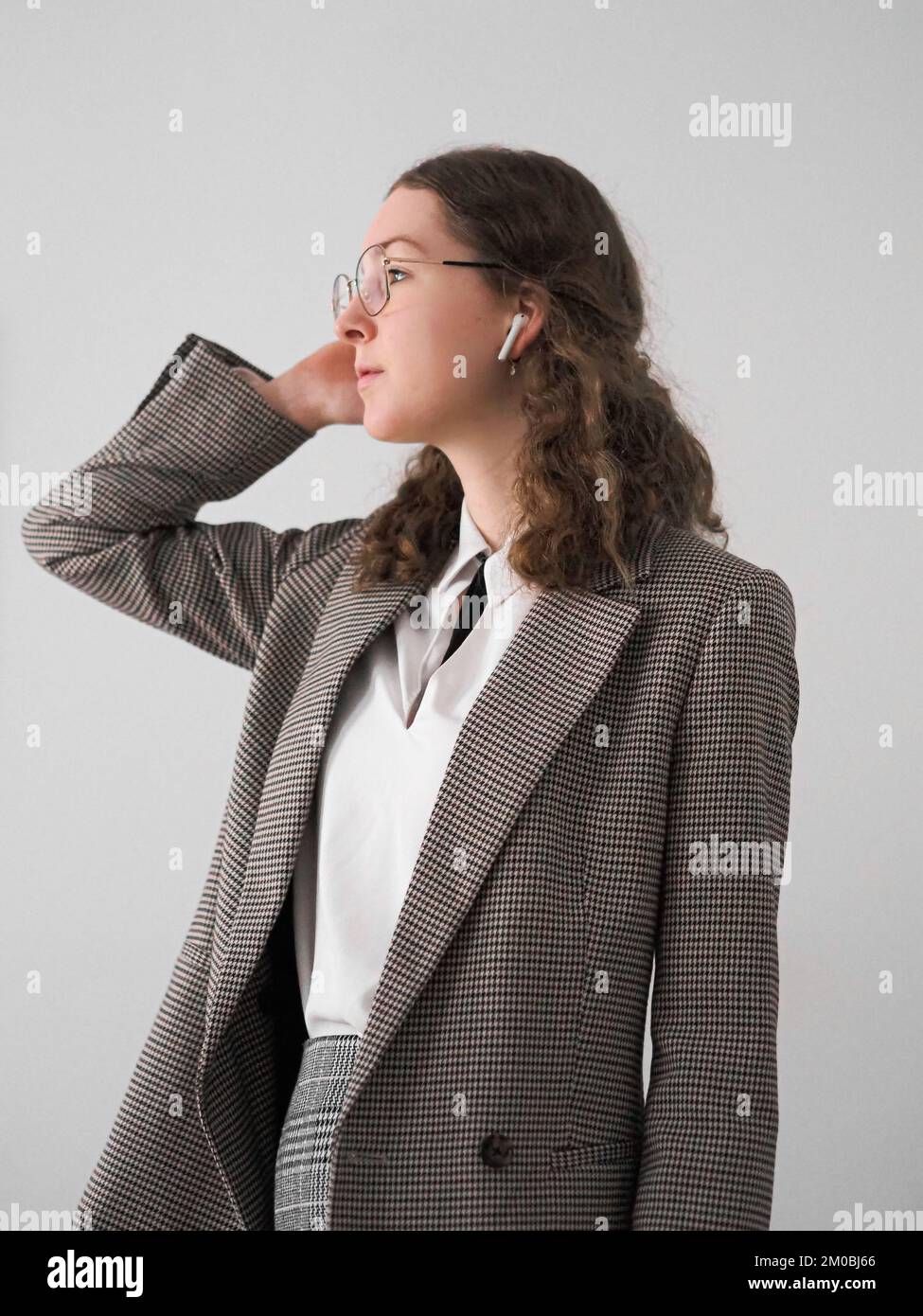 A vertical shot of a young woman dressed in classic style and wearing ...