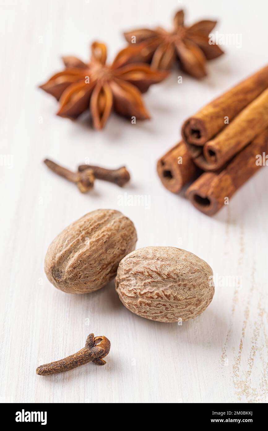 Whole nutmeg seeds, few cloves, star anise, and cinnamon sticks over ...