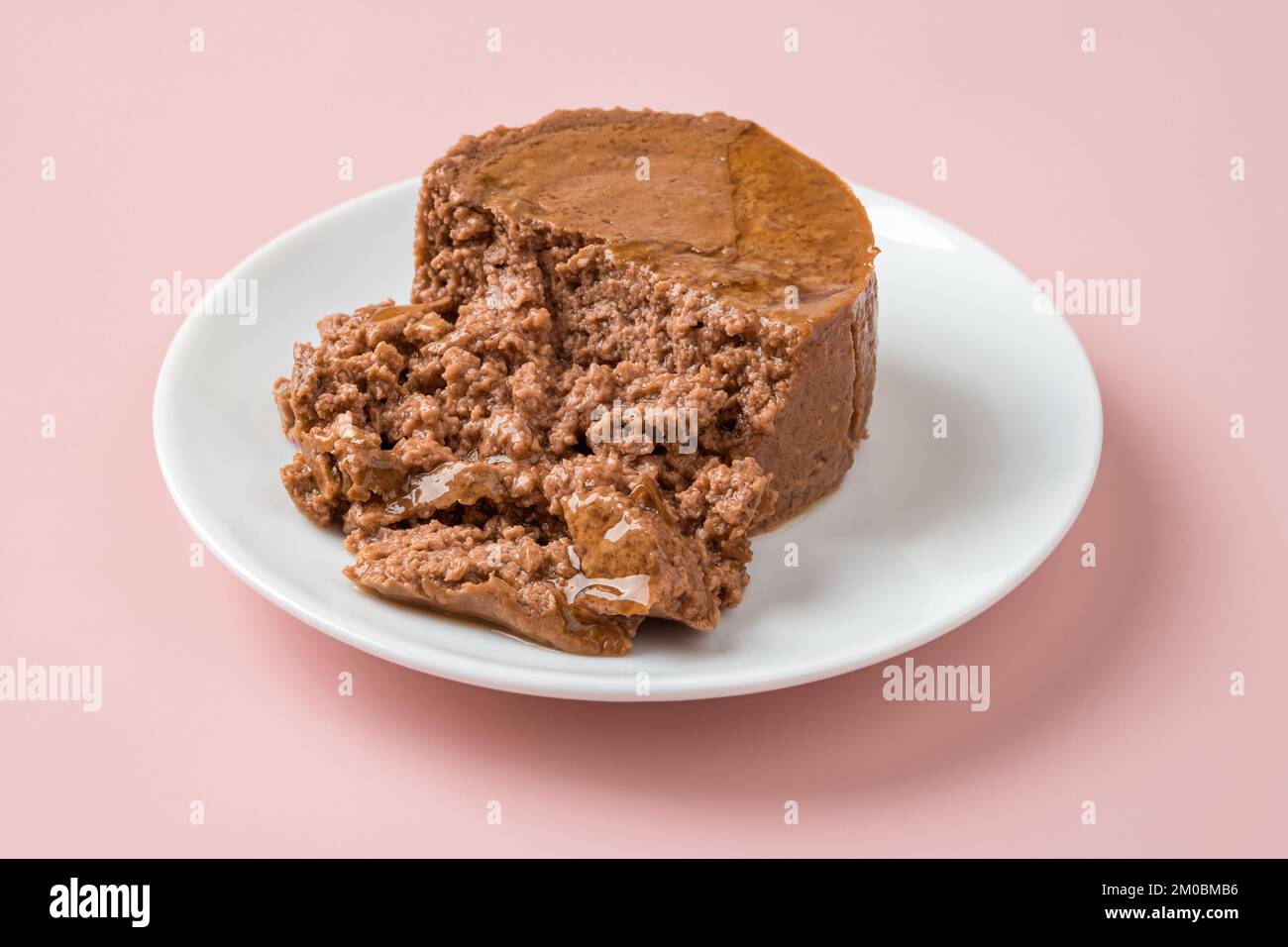Soft pate for cat on a white plate over pastel pink background. Canned ...