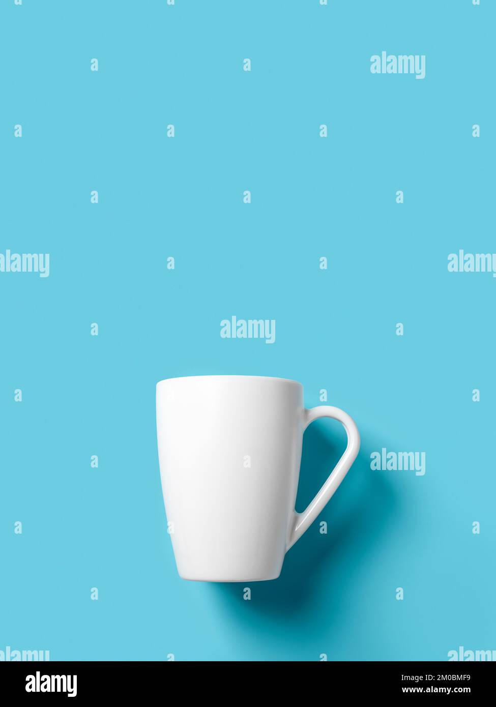 White cup over blue background. Empty mug against turquoise surface ...