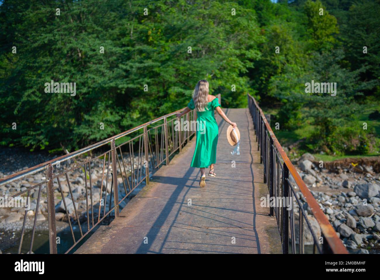 a girl in green walks across the bridge Stock Photo - Alamy