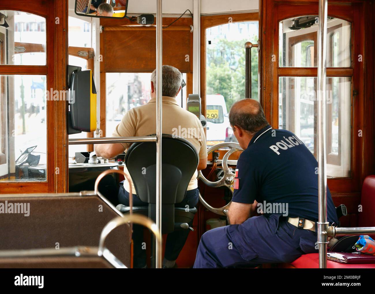 The inside of a historical tram line 28 lisbon with a driver and police ...