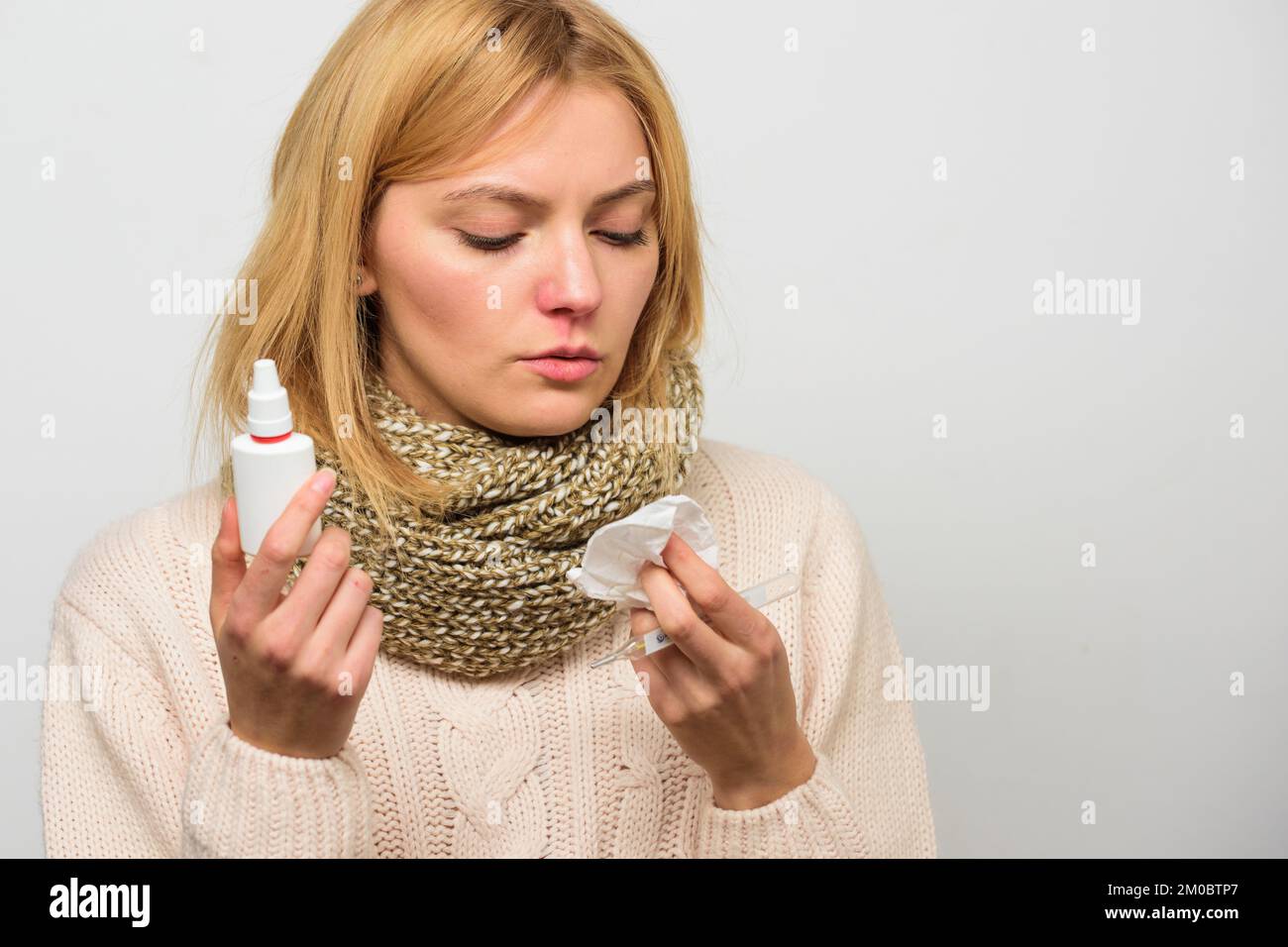 Girl in scarf hold nasal spray and tissue. Cold and flu remedies. Runny ...