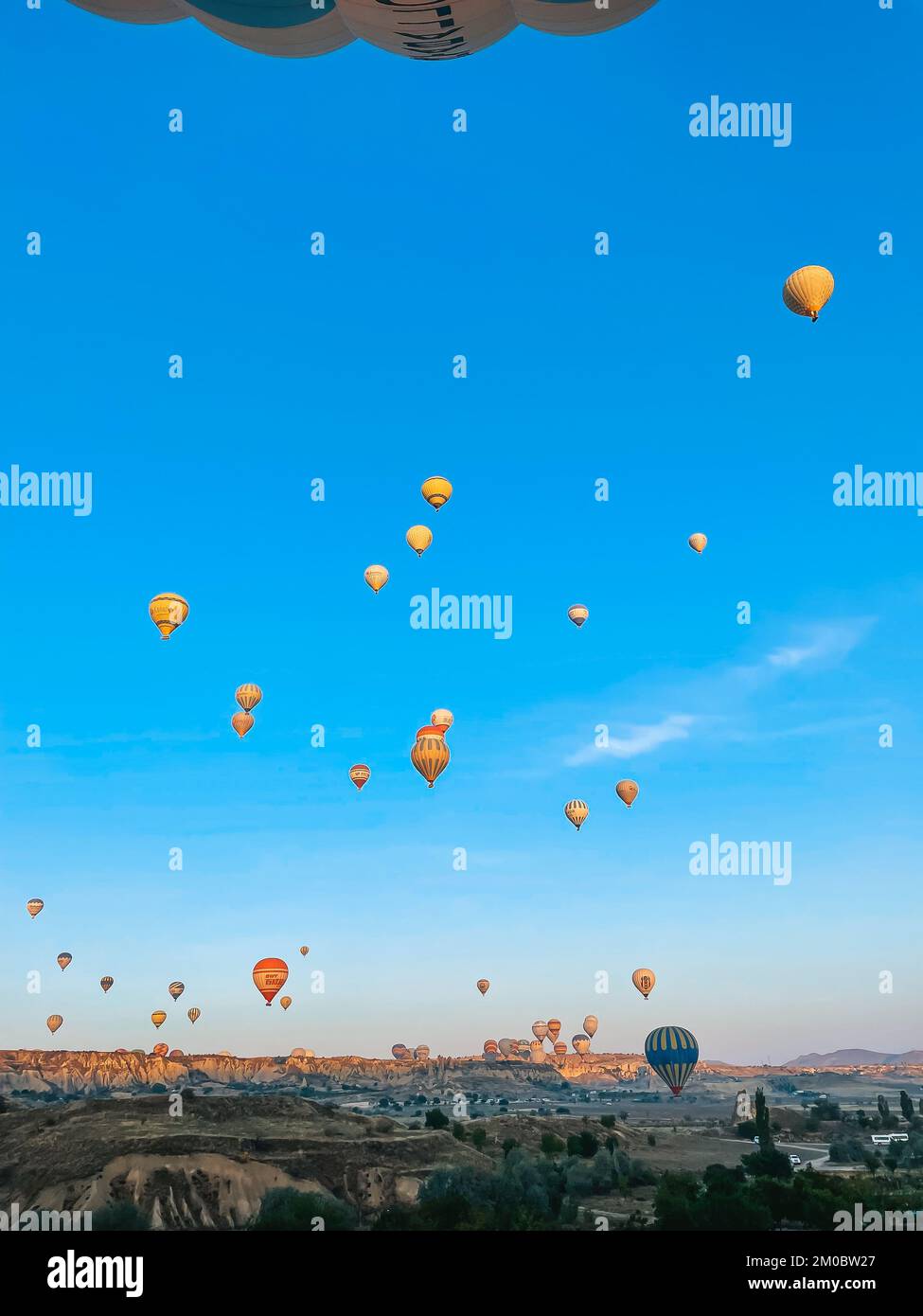 Hot air balloon flying over rocky landscapes in Cappadocia with ...