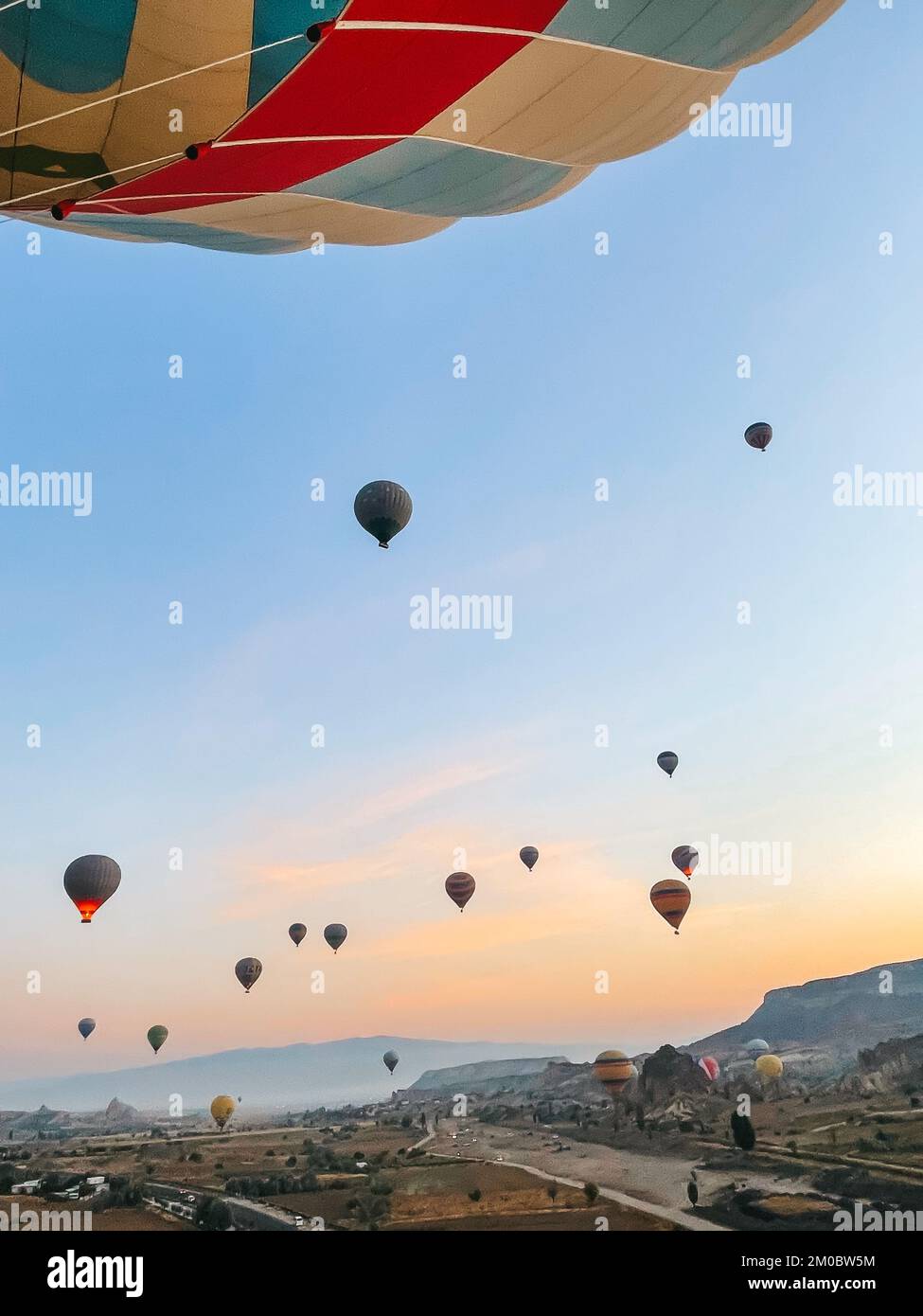 Hot air balloon flying over rocky landscapes in Cappadocia with ...