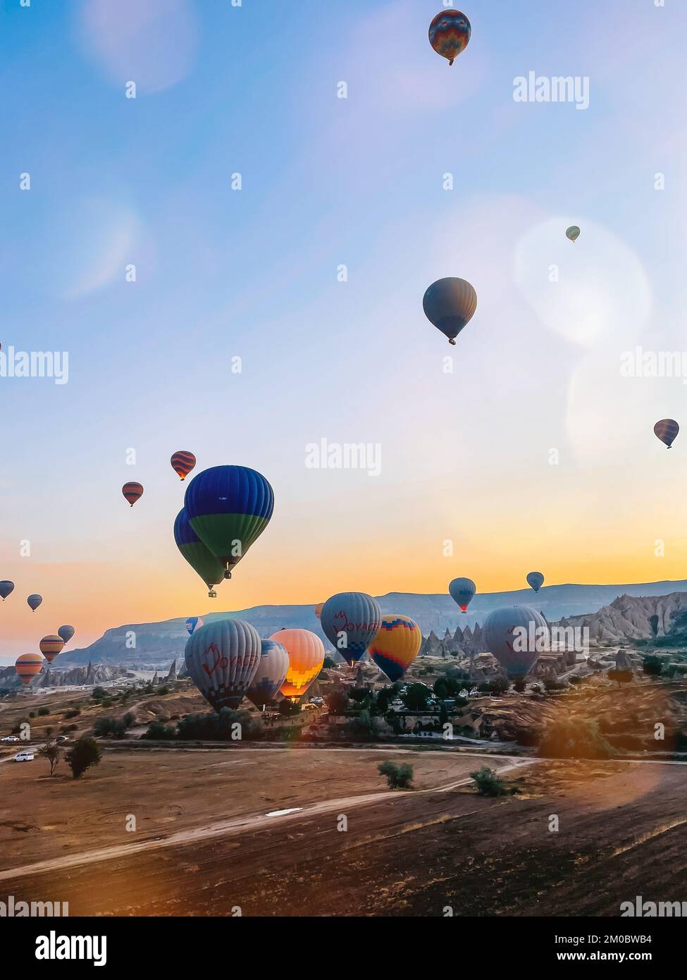 Hot air balloon flying over rocky landscapes in Cappadocia with ...