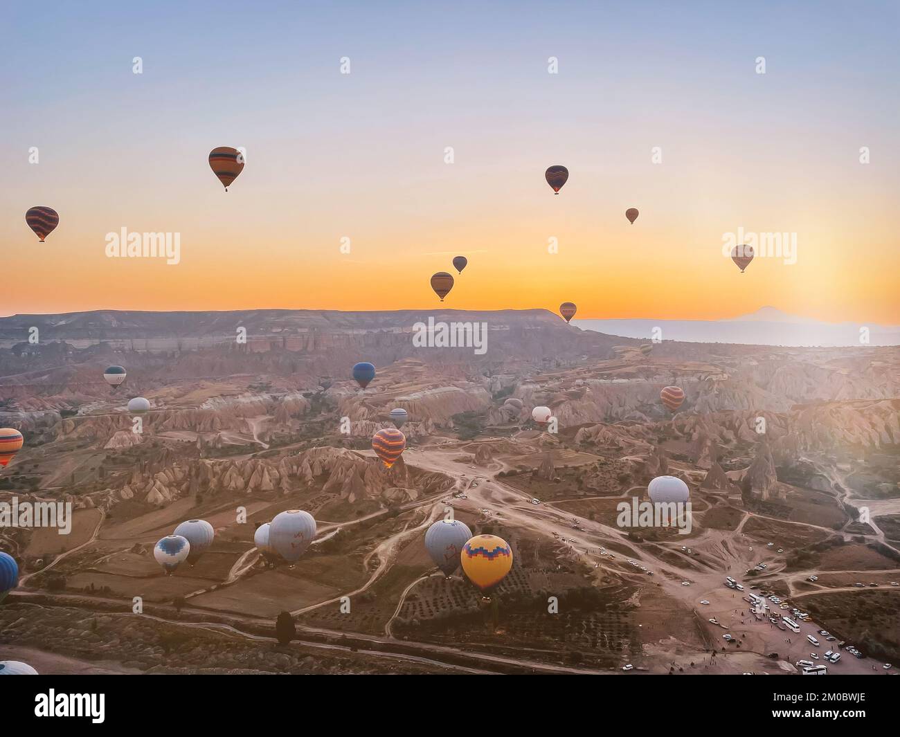 Hot air balloon flying over rocky landscapes in Cappadocia with ...