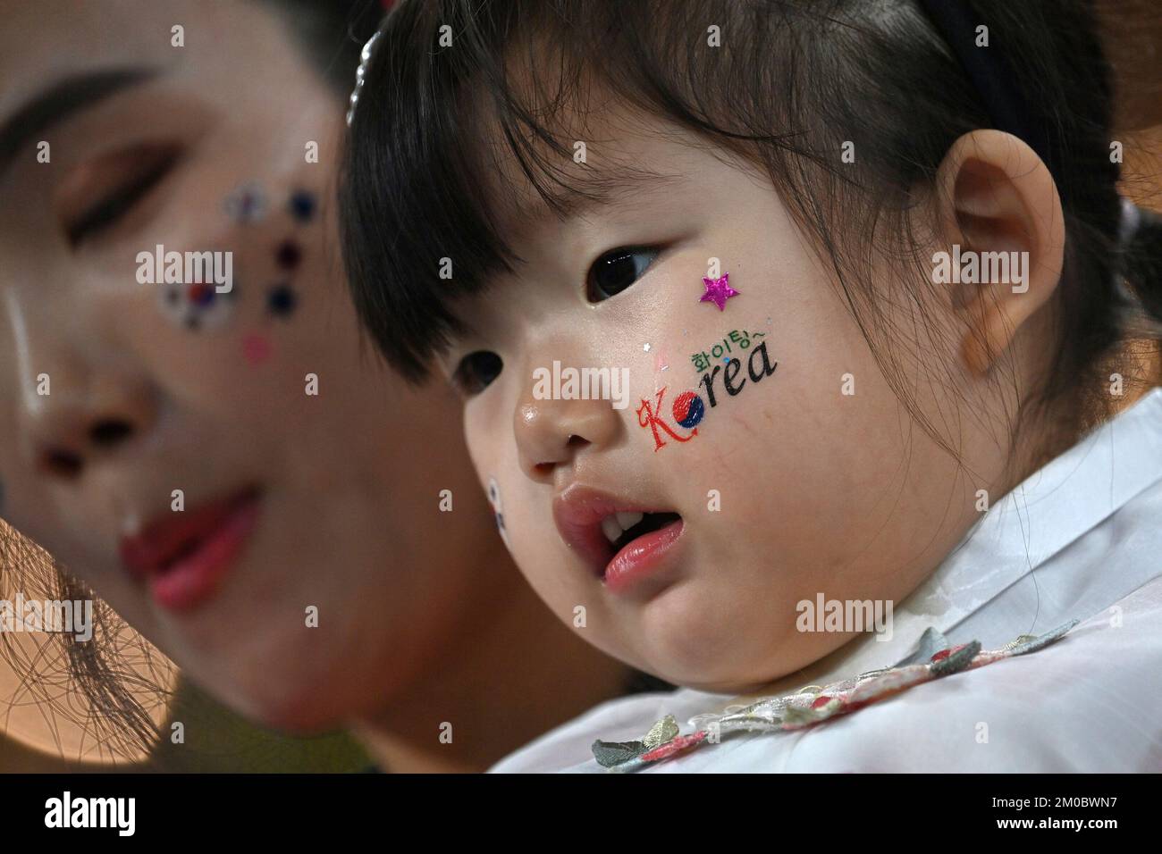 Qatar, 05/12/2022, Young Korean toddler, girl, fan, soccer fan, with Korea face painting. Round ...