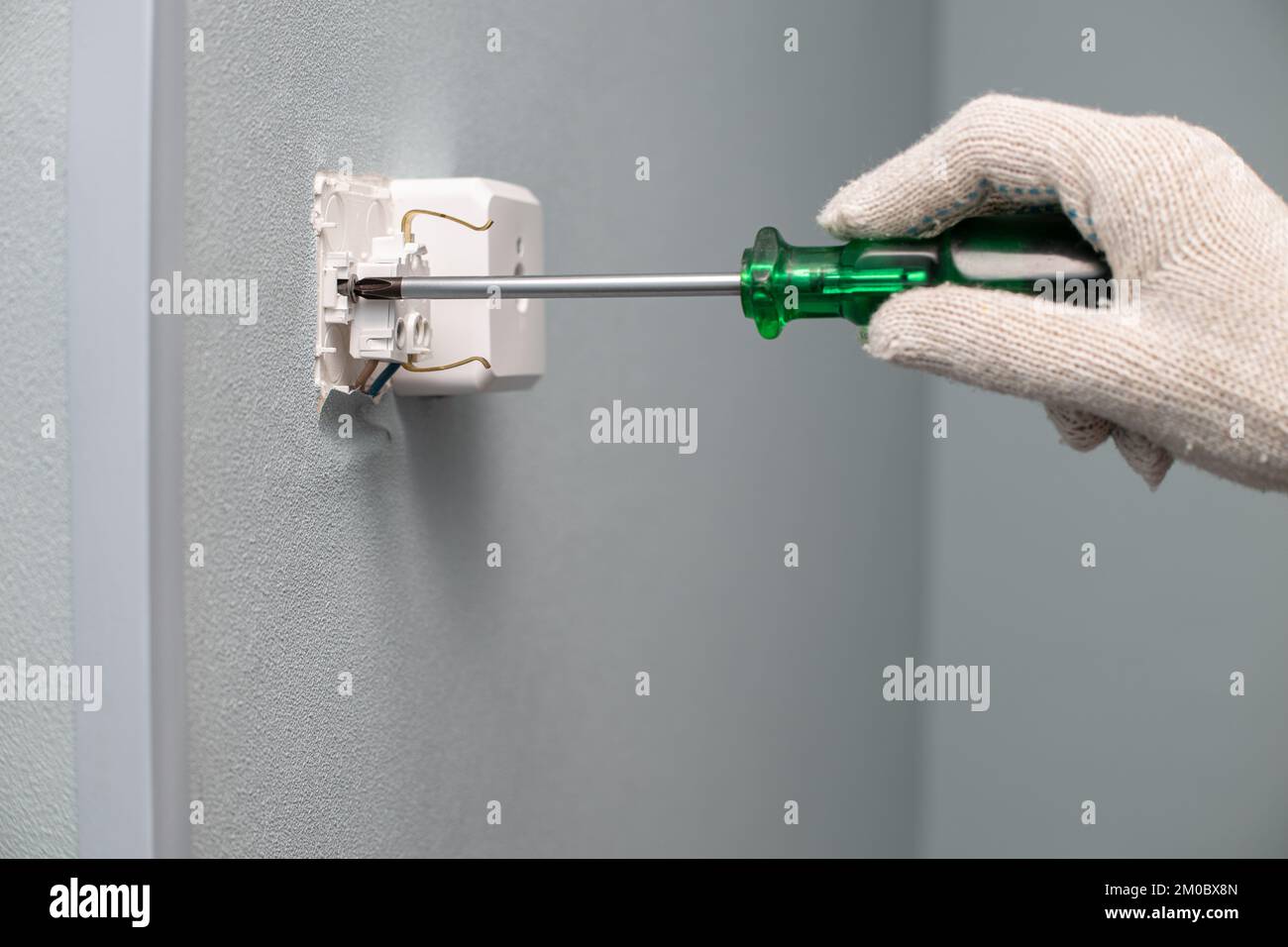 master repairing electrical outlet in the house. man repairing an ...