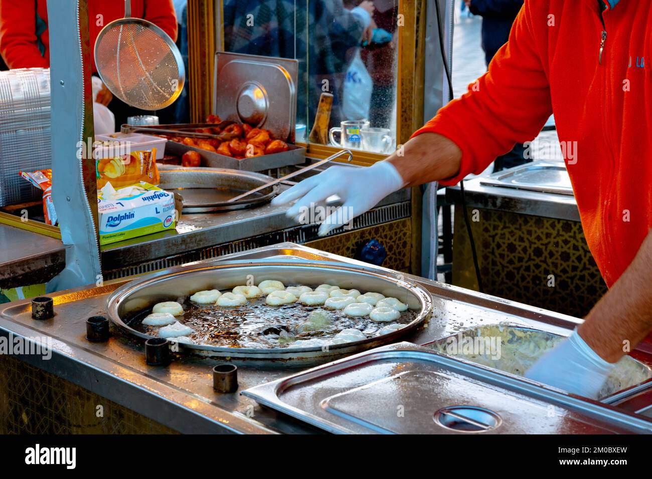 Man frying lokma in the oil on a street food cart. Traditional Turkish ...