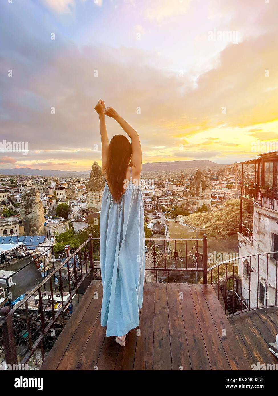 Young woman in dress on the roof with amazing view of Cappadocia in ...