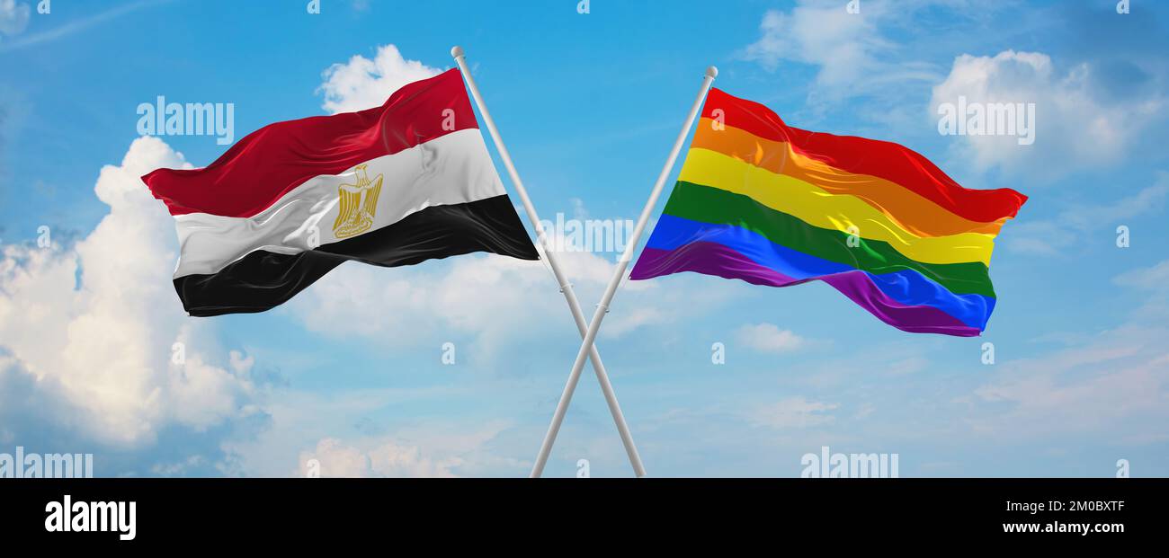 two crossed flags LGBT Pride and Egypt waving in wind at cloudy sky. Concept of relationship ...