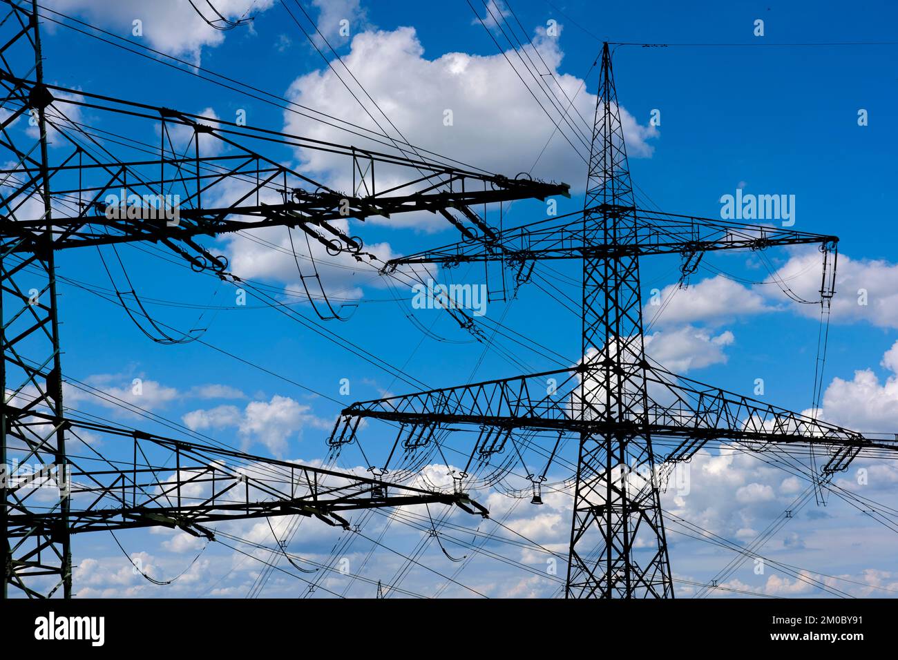 high voltage and electric pylons against sky with clouds Stock Photo ...