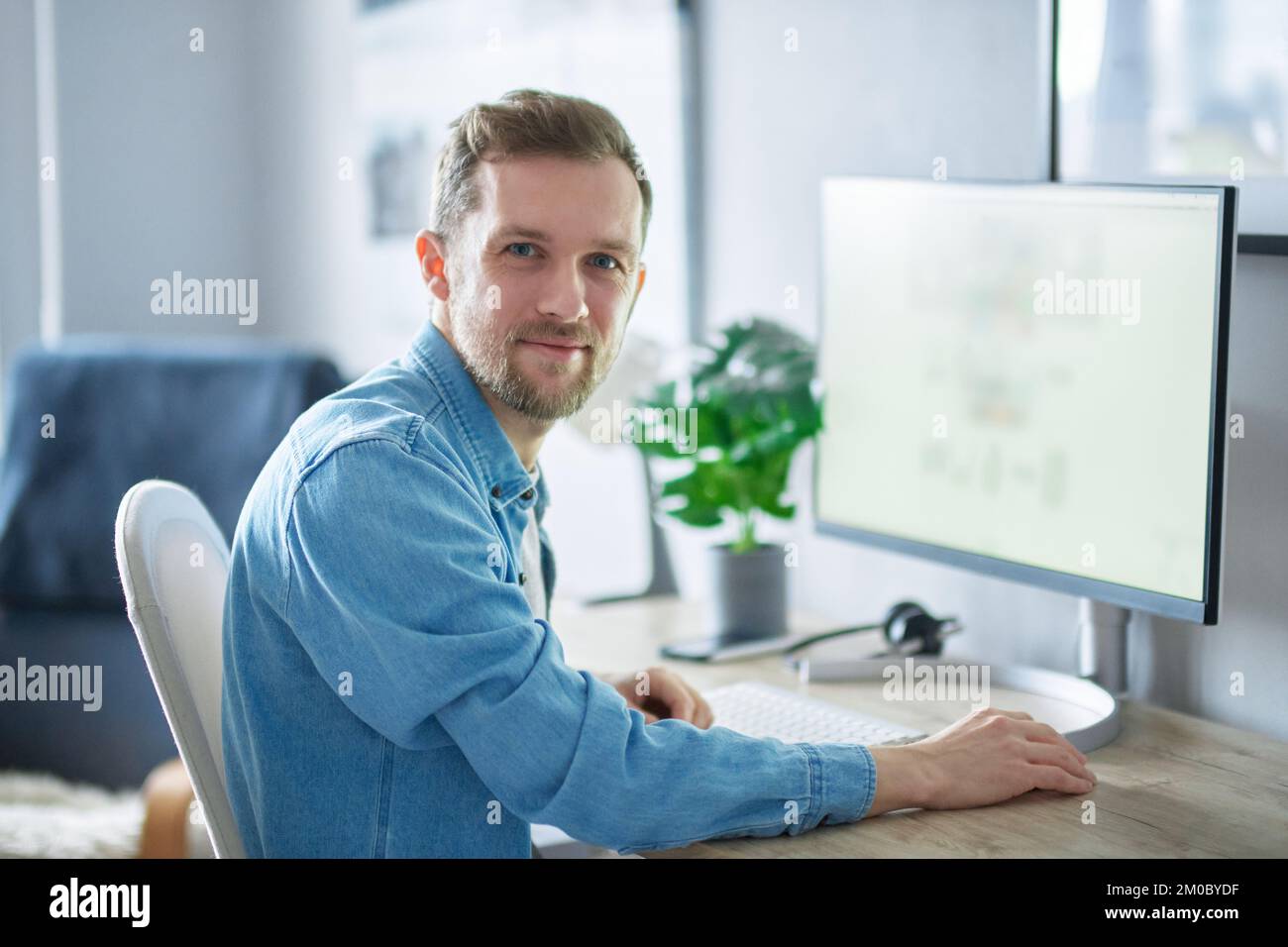 Young handsome IT support man in denim shirt . Attractive bearded ...