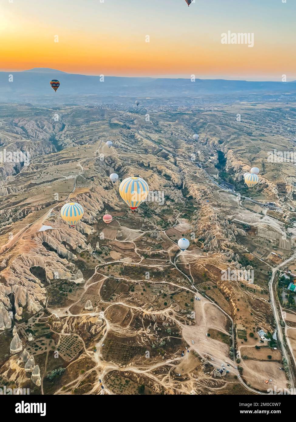 Hot air balloon flying over rocky landscapes in Cappadocia with ...