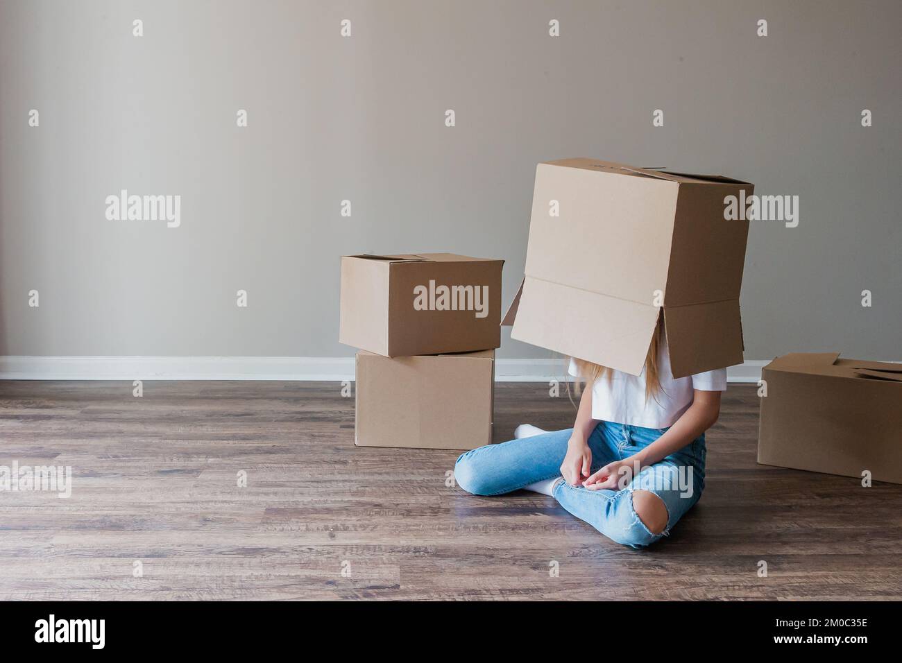 Beautiful young girl moving in new house with cardboard boxes Stock ...