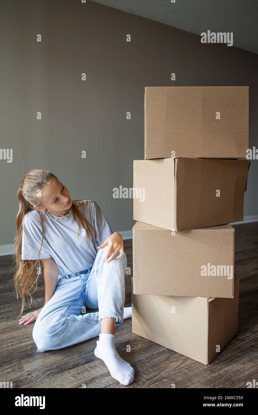 Happy girl moving in new house with cardboard boxes Stock Photo - Alamy