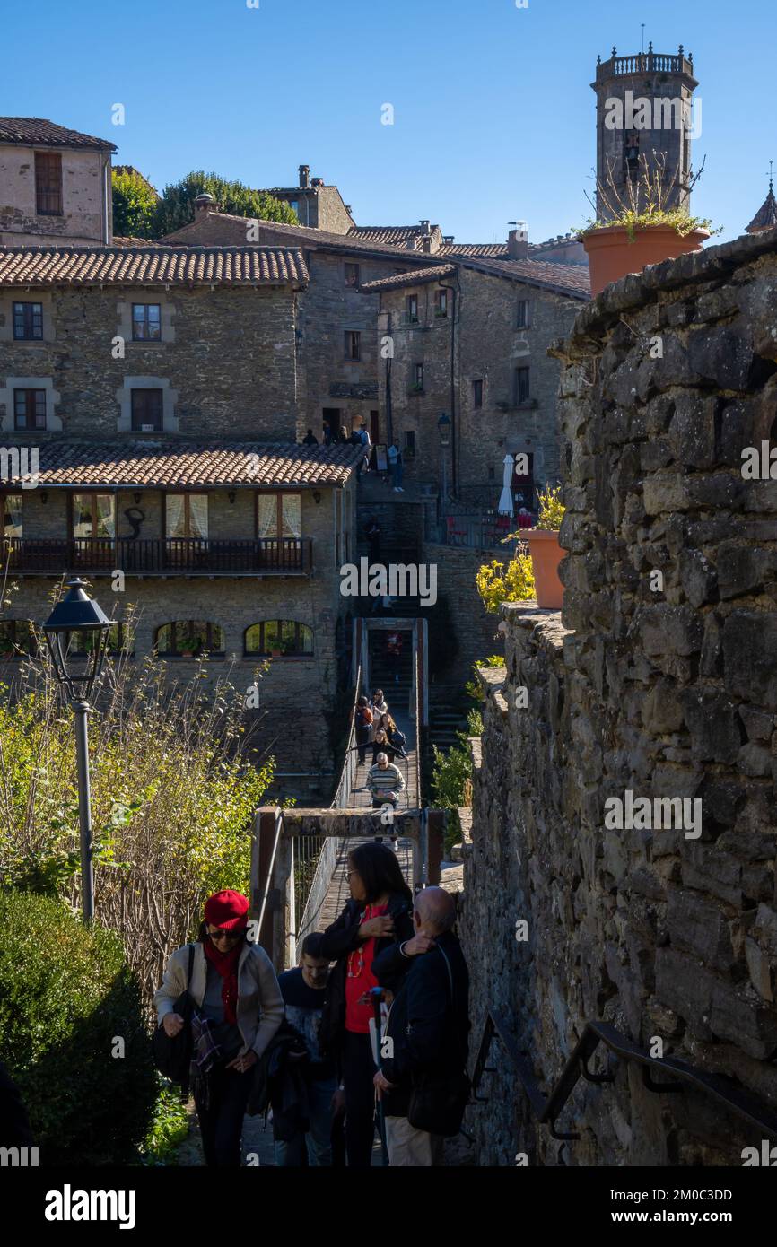 People crossing the suspension bridge of Rupit and old houses in the ...