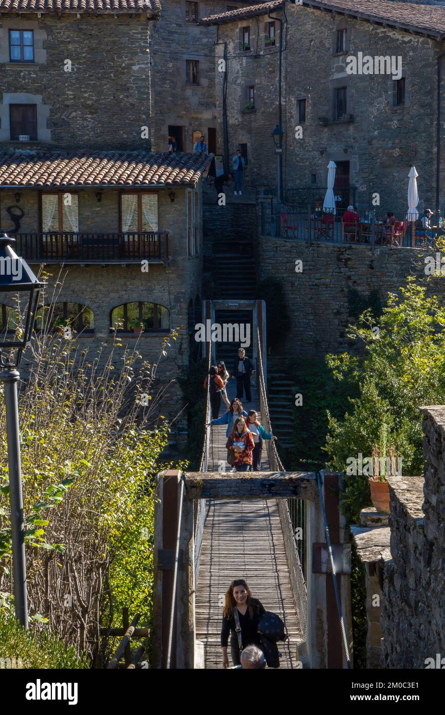 People crossing the suspension bridge of Rupit and old houses in the ...