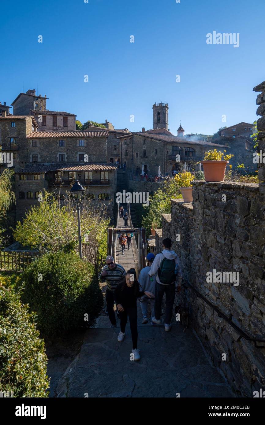 People crossing the suspension bridge of Rupit and old houses in the ...