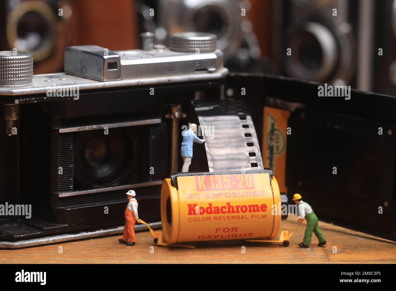 Miniature Workmen Handling Vintage Film and Cameras Stock Photo - Alamy