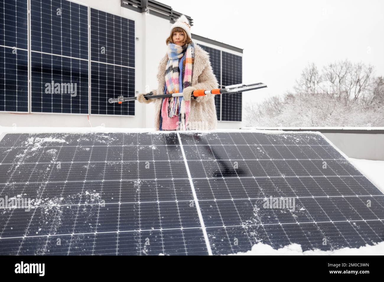 Woman cleans solar panels from snow Stock Photo - Alamy