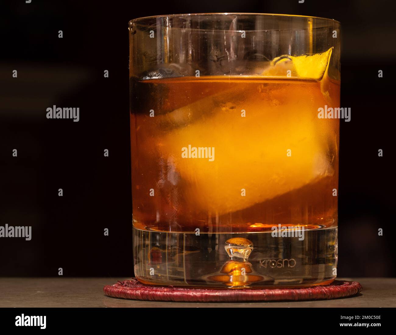 A bourbon whiskey old fashioned with a big ice cube Stock Photo - Alamy