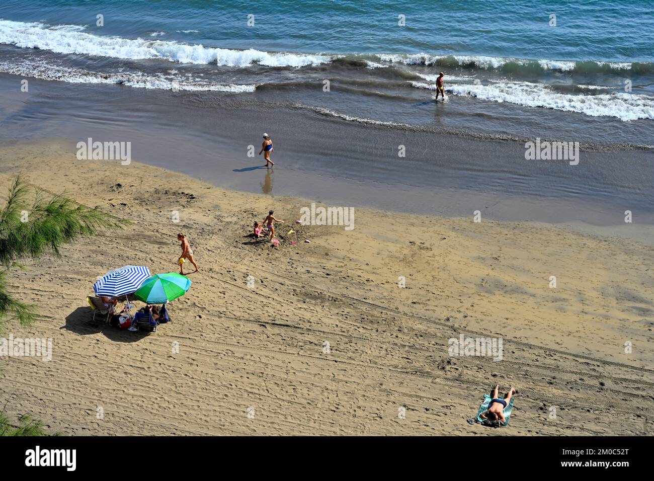 Playa El Veril beach with sunbathers on sand others in the sea, San ...