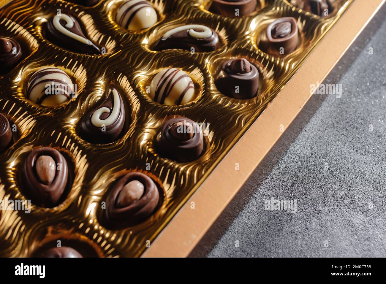 A box of different chocolates. Chocolate assortment mix on the black ...