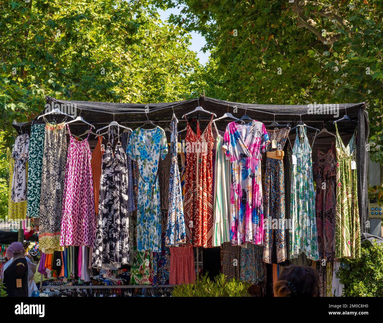 Flea market stall with women's clothing in a market. All colorful and ...