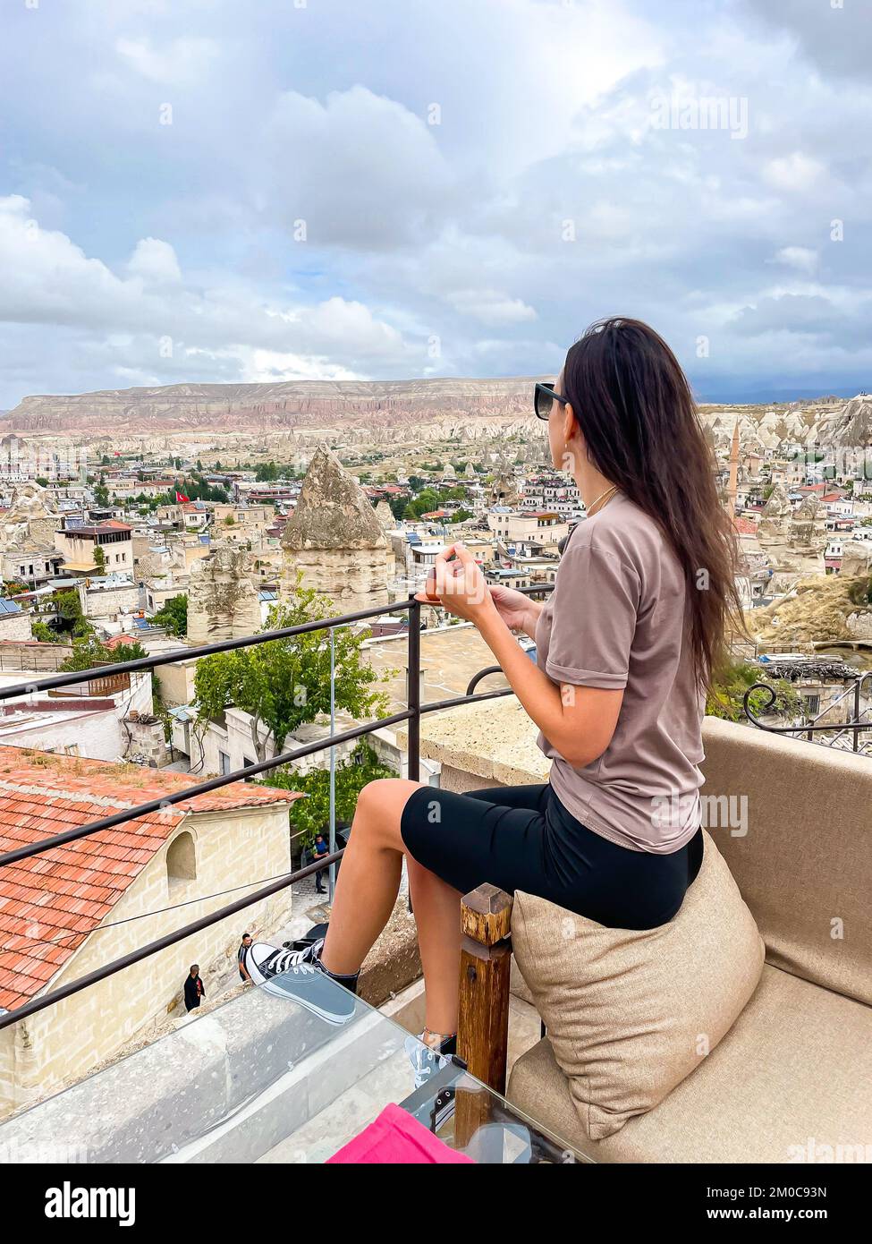 Young woman in dress on the roof with amazing view of Cappadocia in ...
