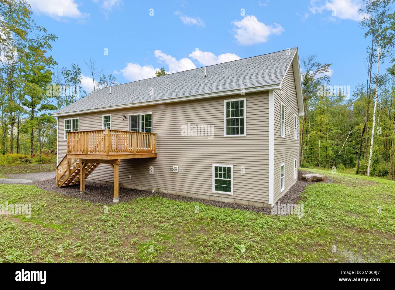 A grey modern construction of contemporary raised ranch surrounded by ...