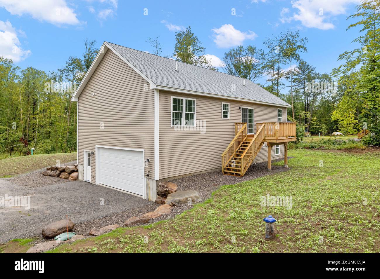 A grey modern construction of contemporary raised ranch surrounded by ...