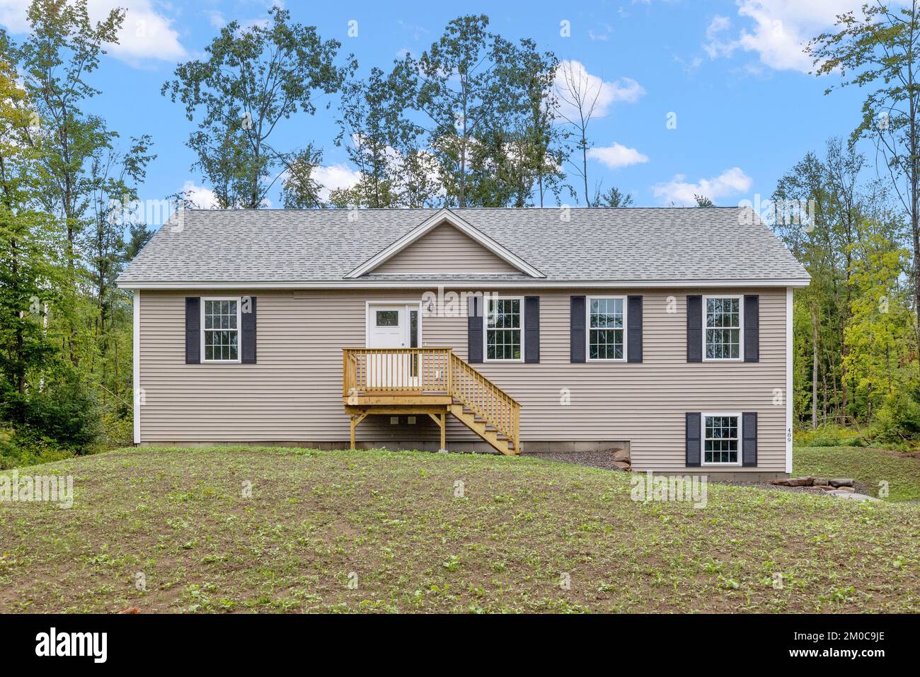 A grey modern construction of contemporary raised ranch surrounded by ...